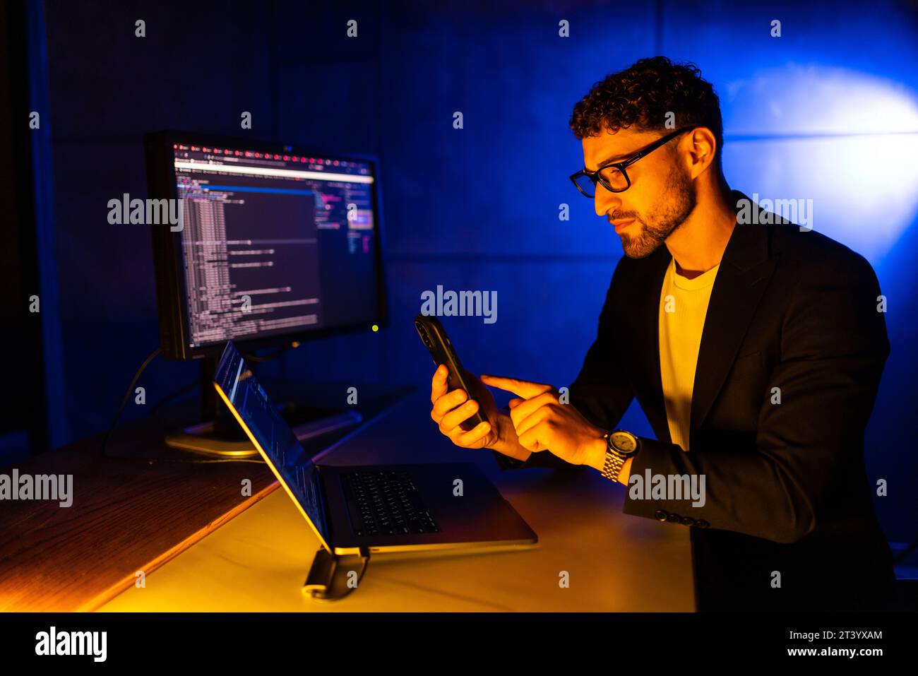 Photo of smart serious guy chatting typing coworking lamp light night ...