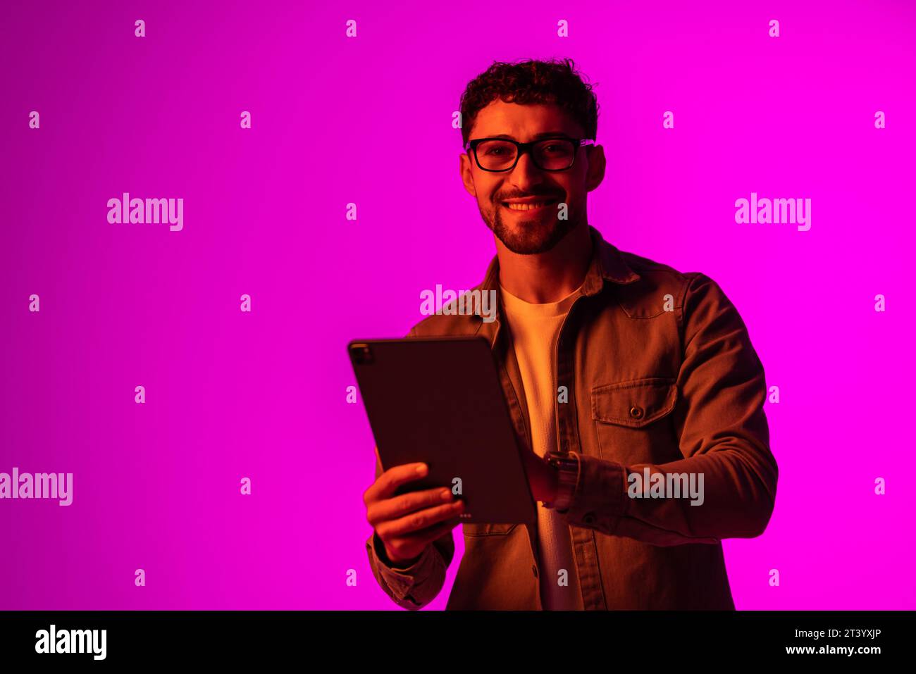 Using tablet. Young Caucasian man with modern digital device isolated ...