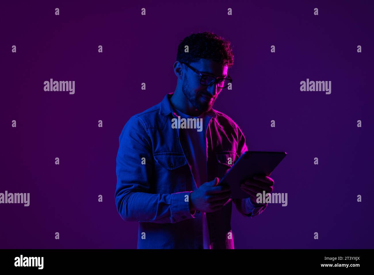 Using tablet. Young Caucasian man with modern digital device isolated ...