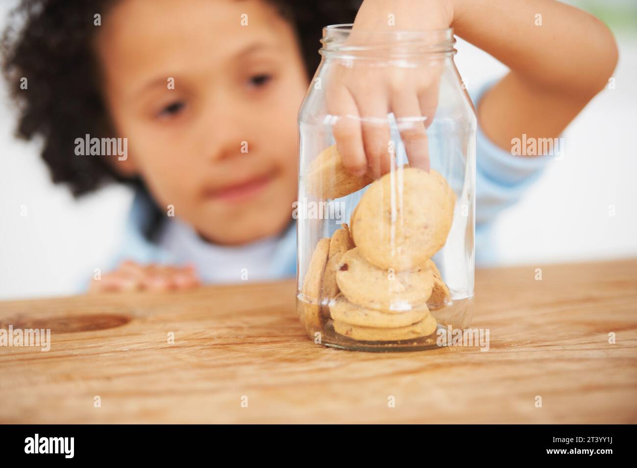 Cute, cookie jar and boy child by the kitchen counter eating a sweet ...