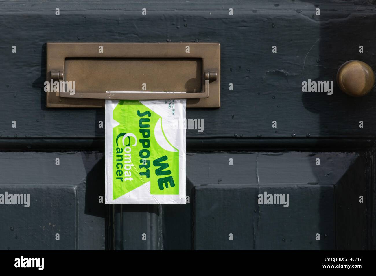 Charity bag in a front door letter box, combat cancer charity bag, UK ...