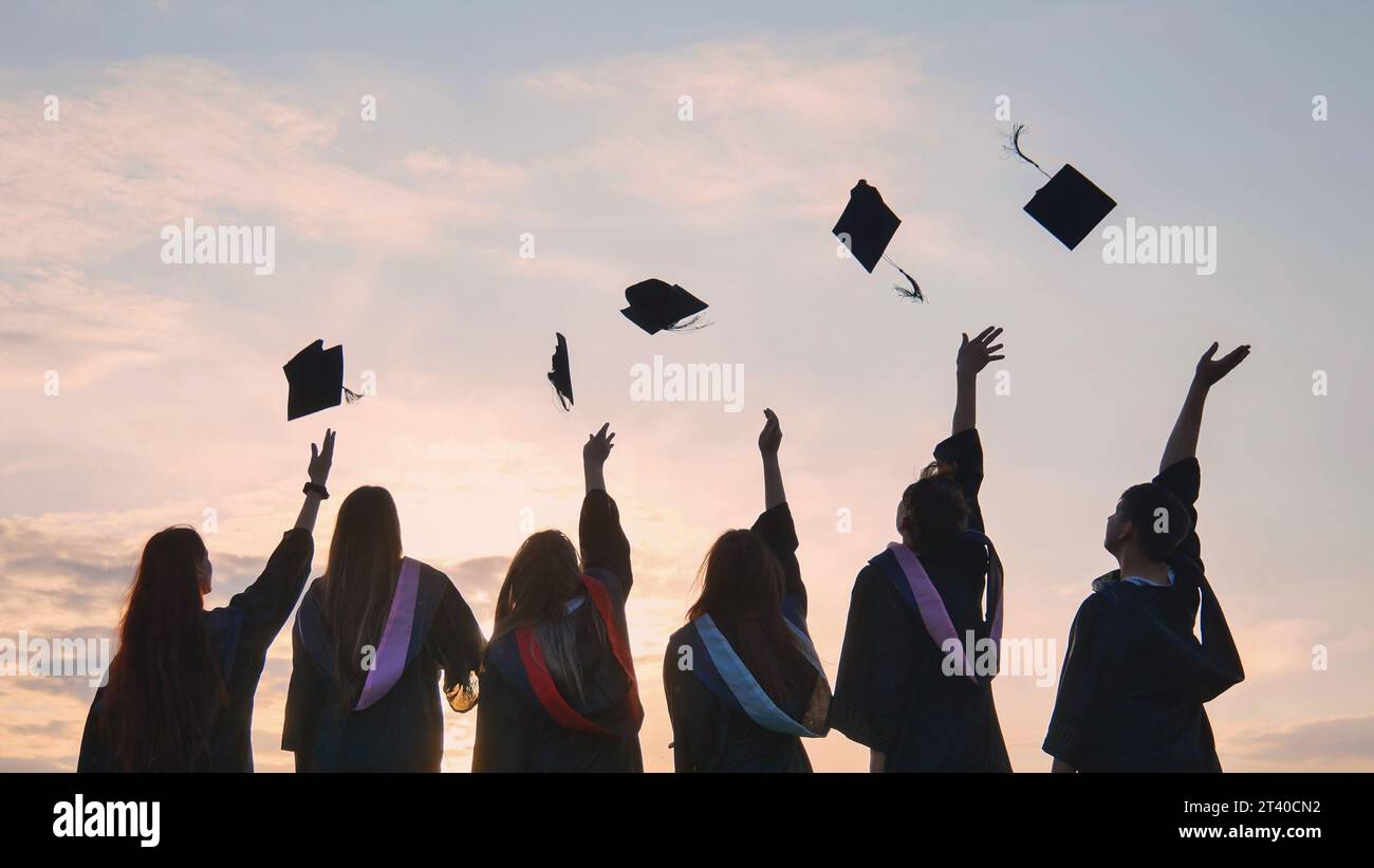 Student graduates toss their caps at sunset Stock Photo - Alamy