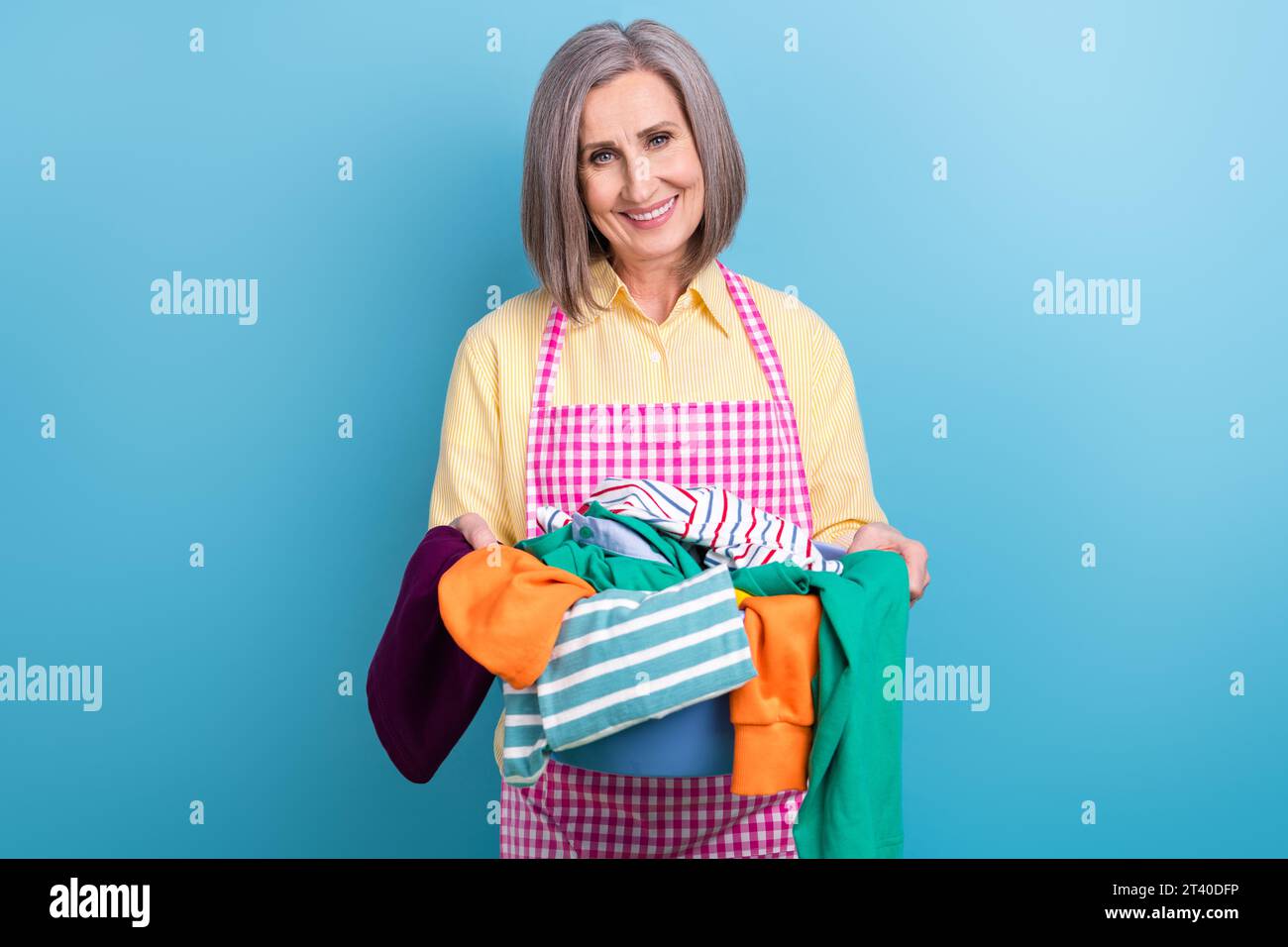 Portrait of cheerful nice person toothy smile arms hold clothes laundry ...