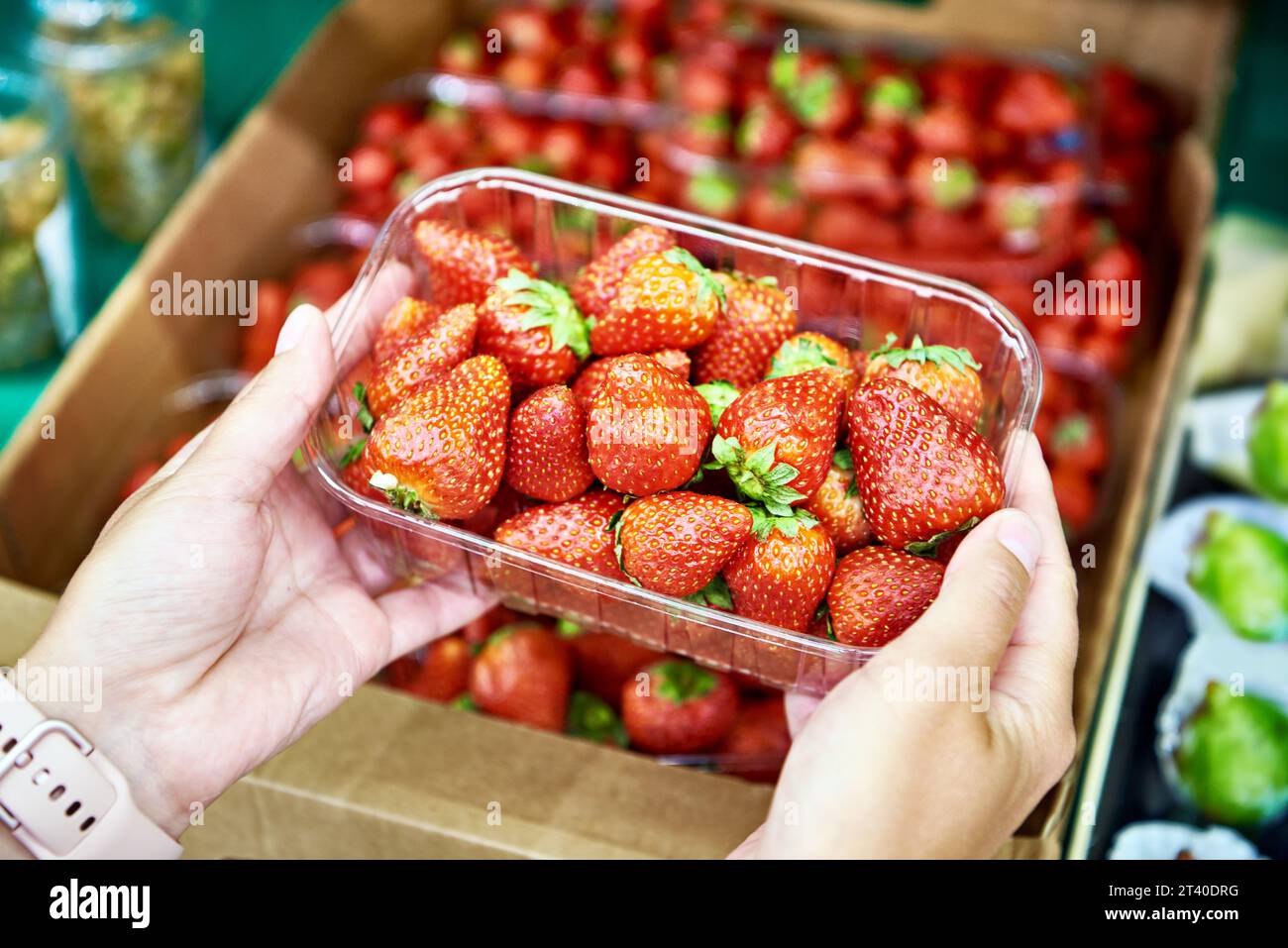 Strawberries in the hands of a buyer in a store Stock Photo - Alamy