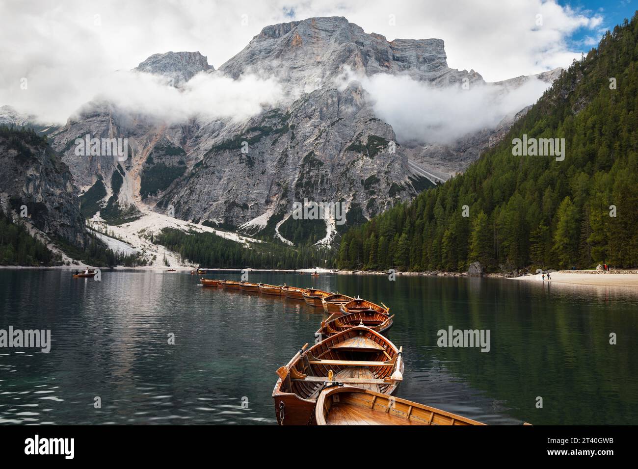 Stunning Lago di Braies with the row of typical wooden boats and ...