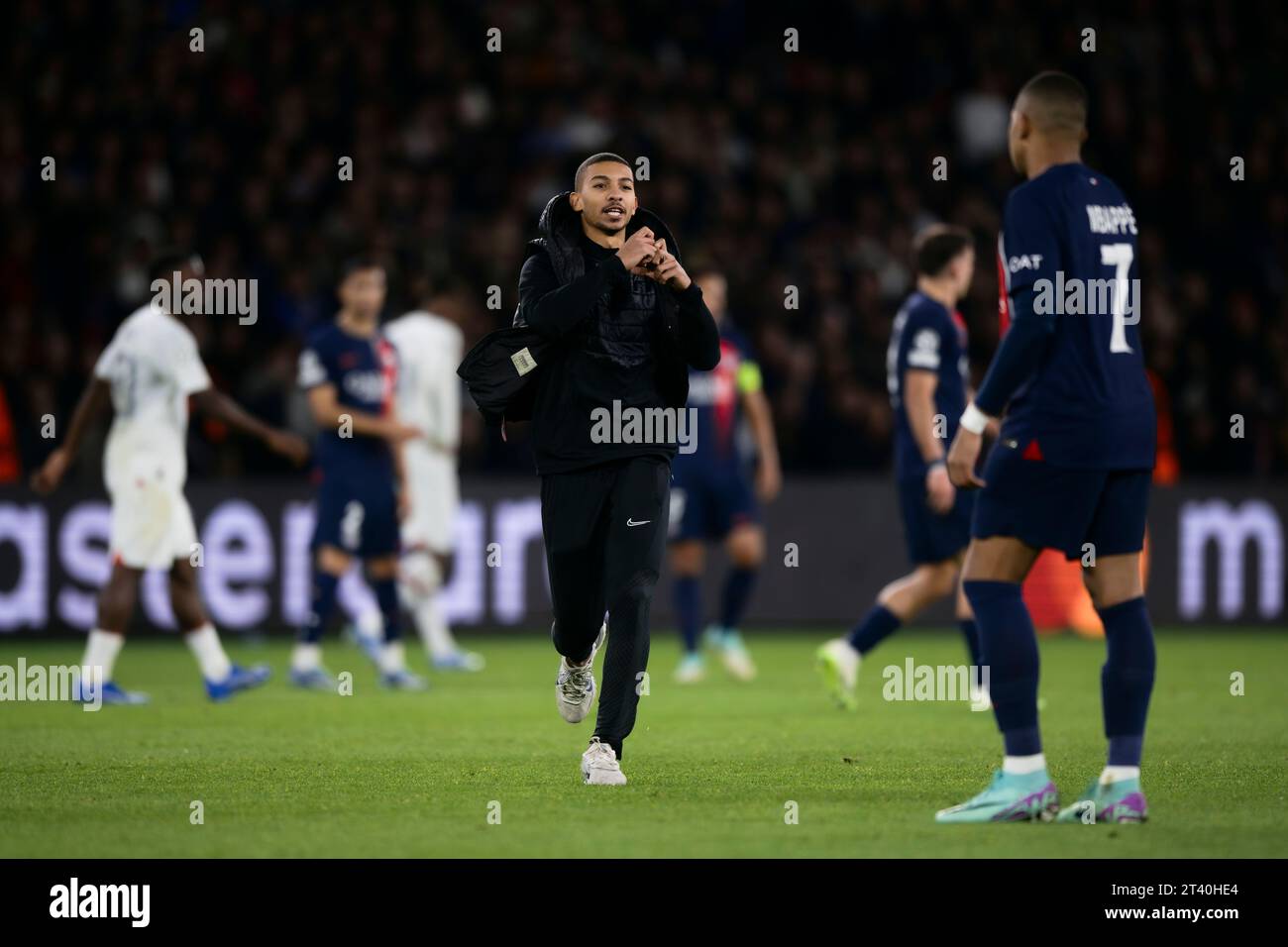 A pitch invader gestures toward Kylian Mbappe of Paris Saint-Germain FC ...