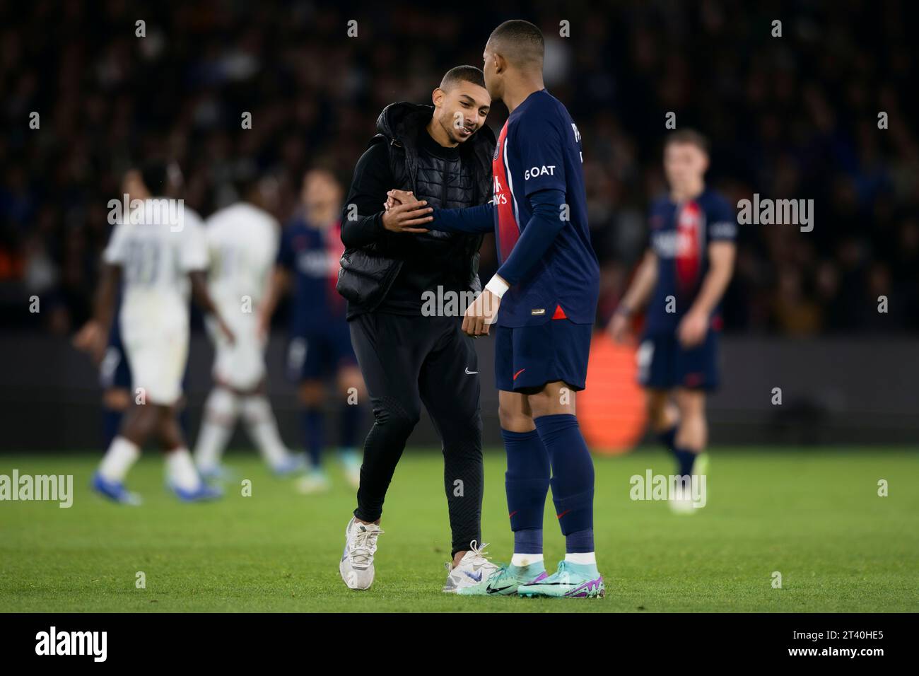 A pitch invader shakes hands with Kylian Mbappe of Paris Saint-Germain ...
