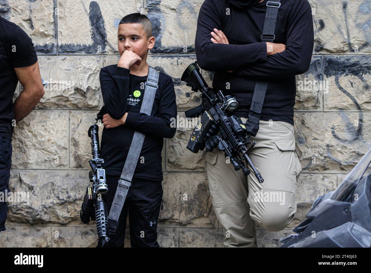 A Palestinian kid with a gun attends the funeral of Aysar al-Amer, 25 ...