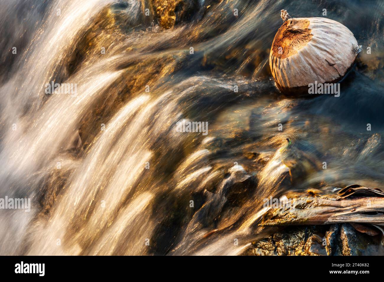Abstract details of water movemet,at sunset.Sunlight shining on rocks ...