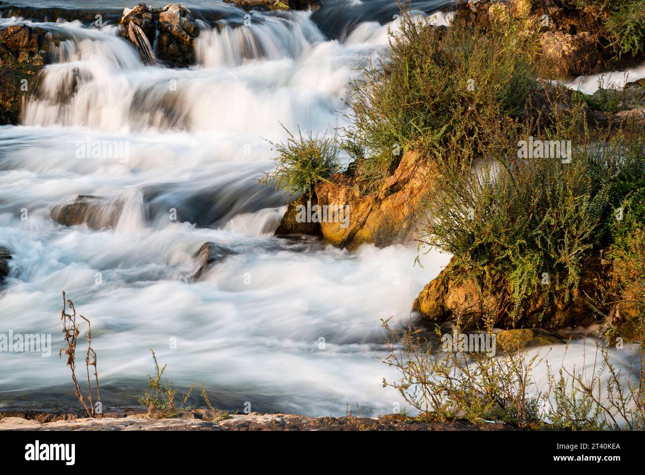 River water details,at sunset.Sunlight shining on rocks,next to blurred ...