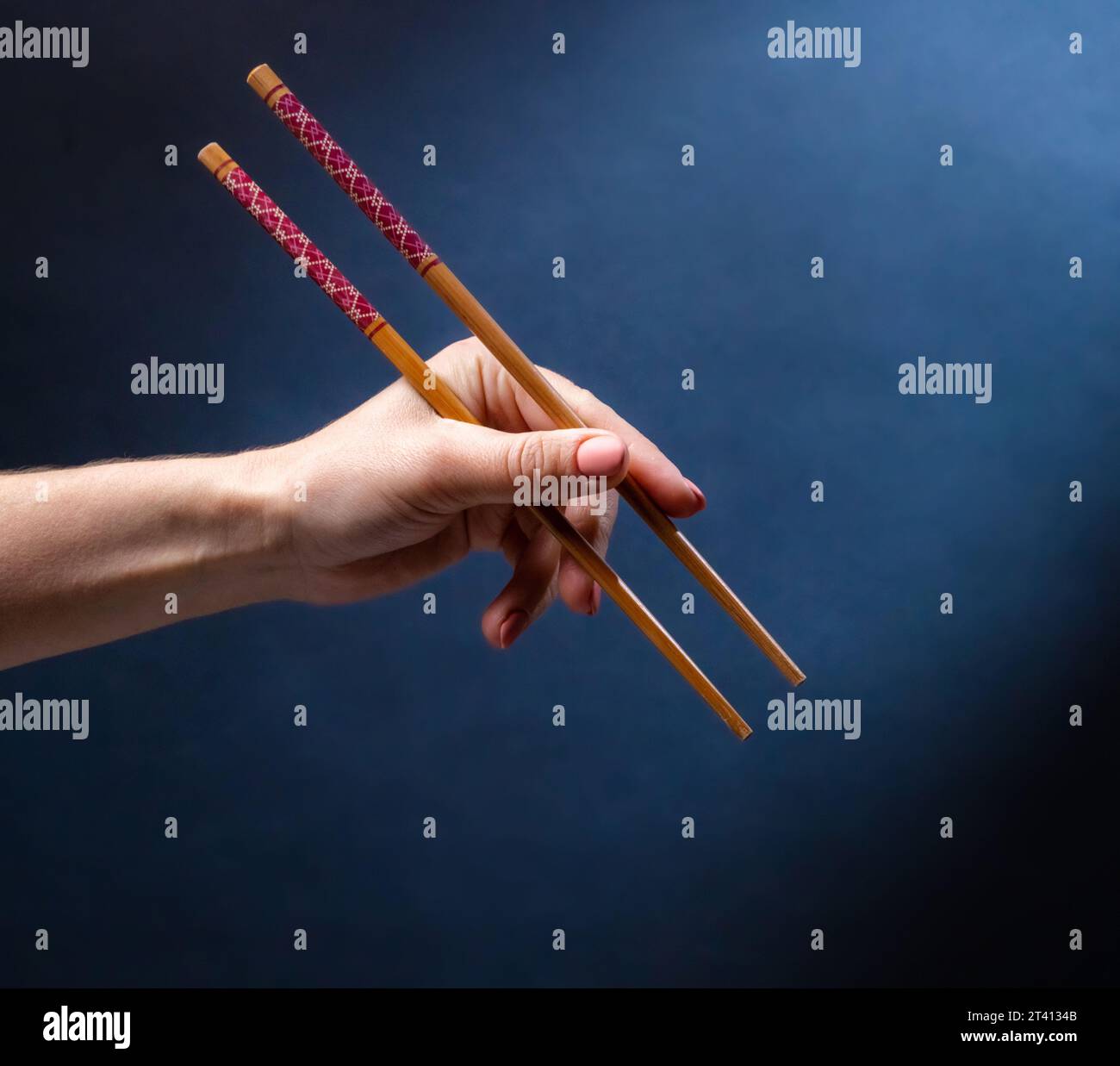Hand holding japanese chopstick for sushi maki food. Traditional bamboo ...