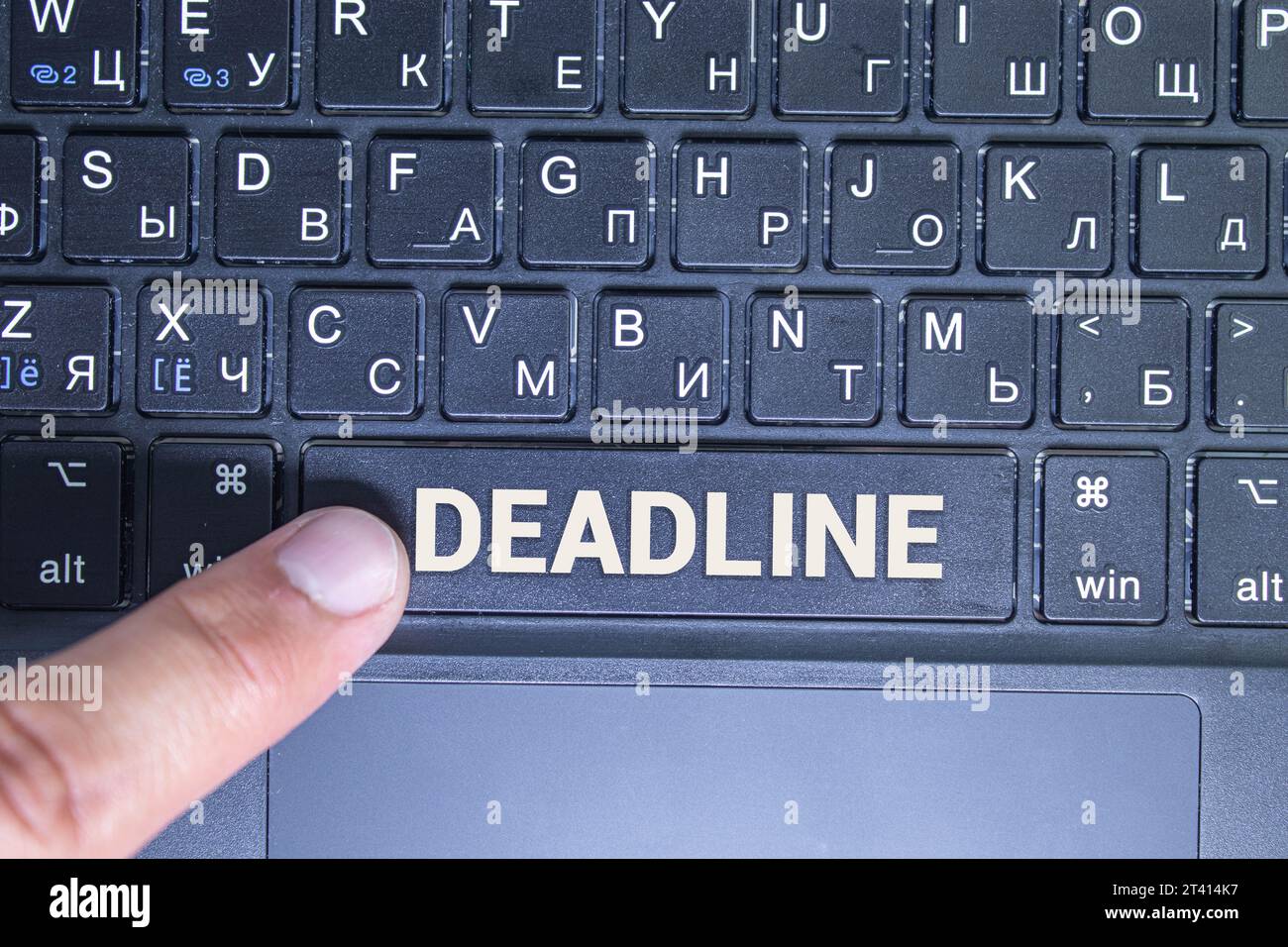 Deadline word written on a post note and hanged on the cork-board with ...