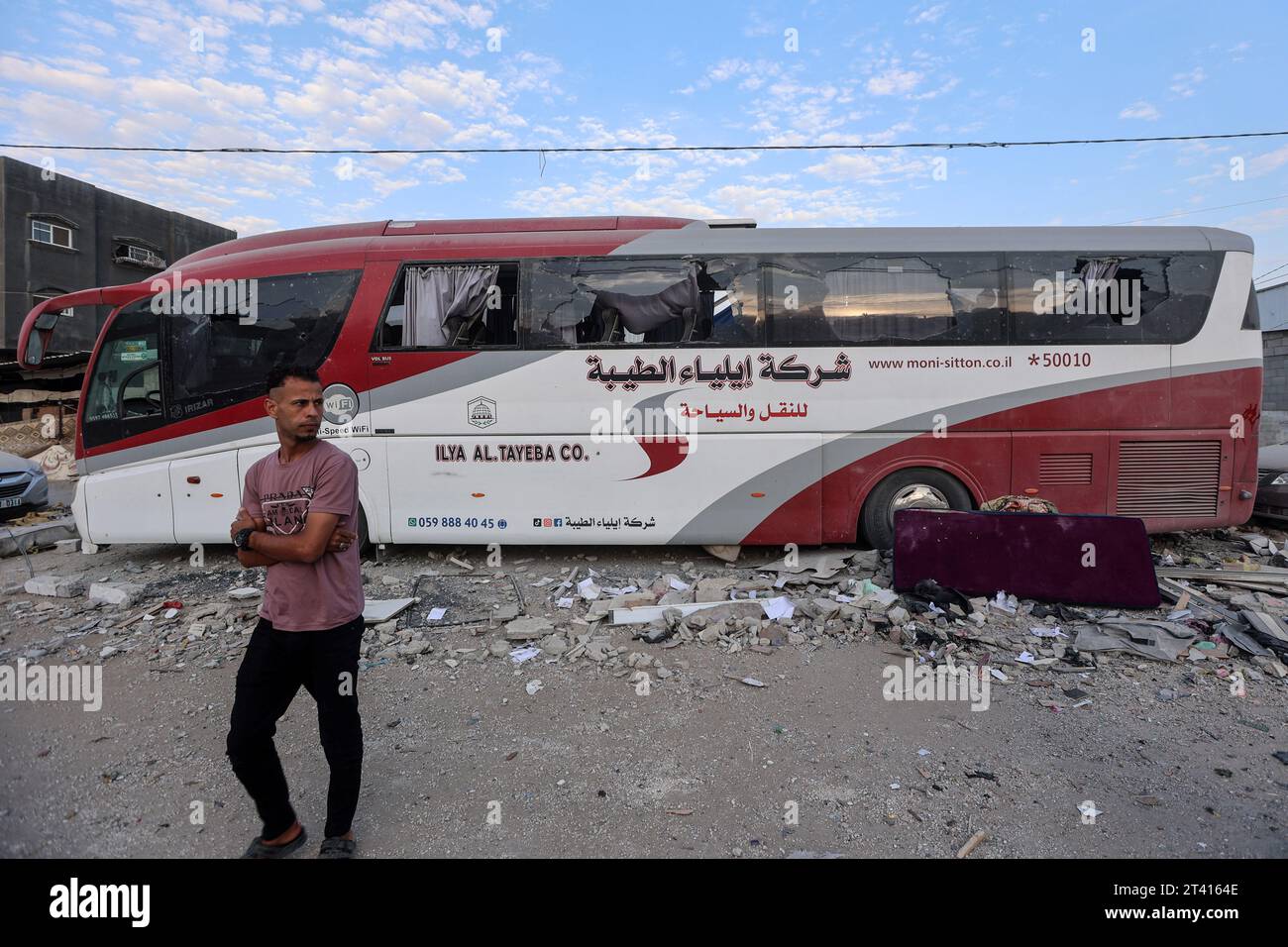 A Palestinian man walks infront a destroyed bus in Khan Yunis, in the ...