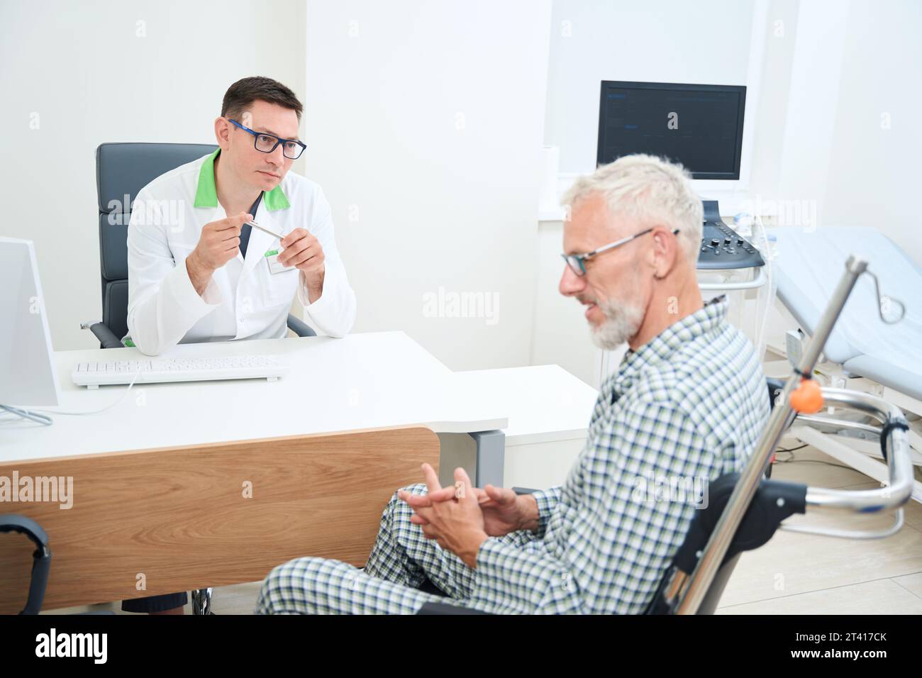 Attending doctor communicates with sad man in doctors office Stock ...