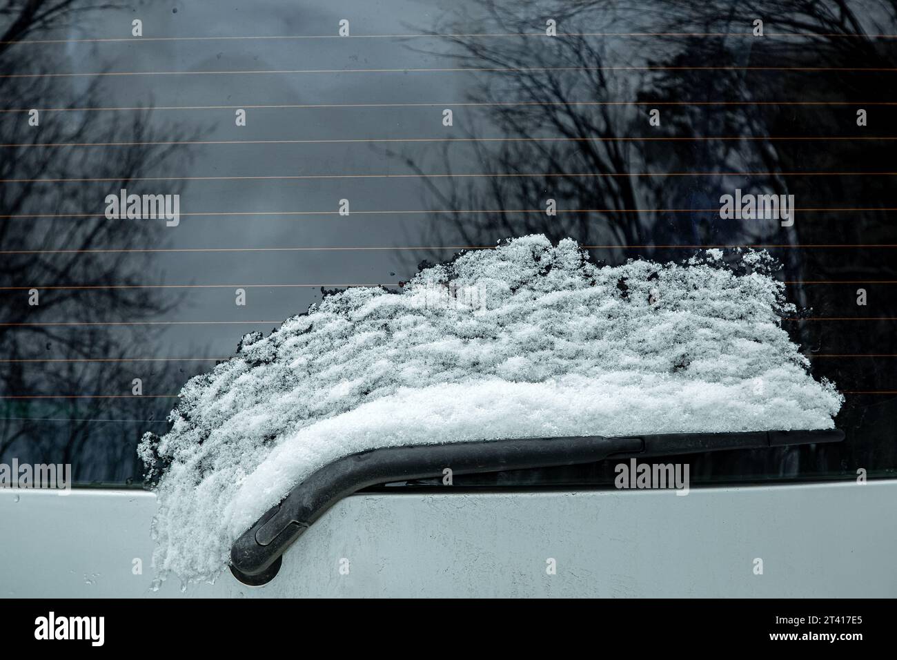 windshield wiper of the rear window of a car covered with a layer of ...