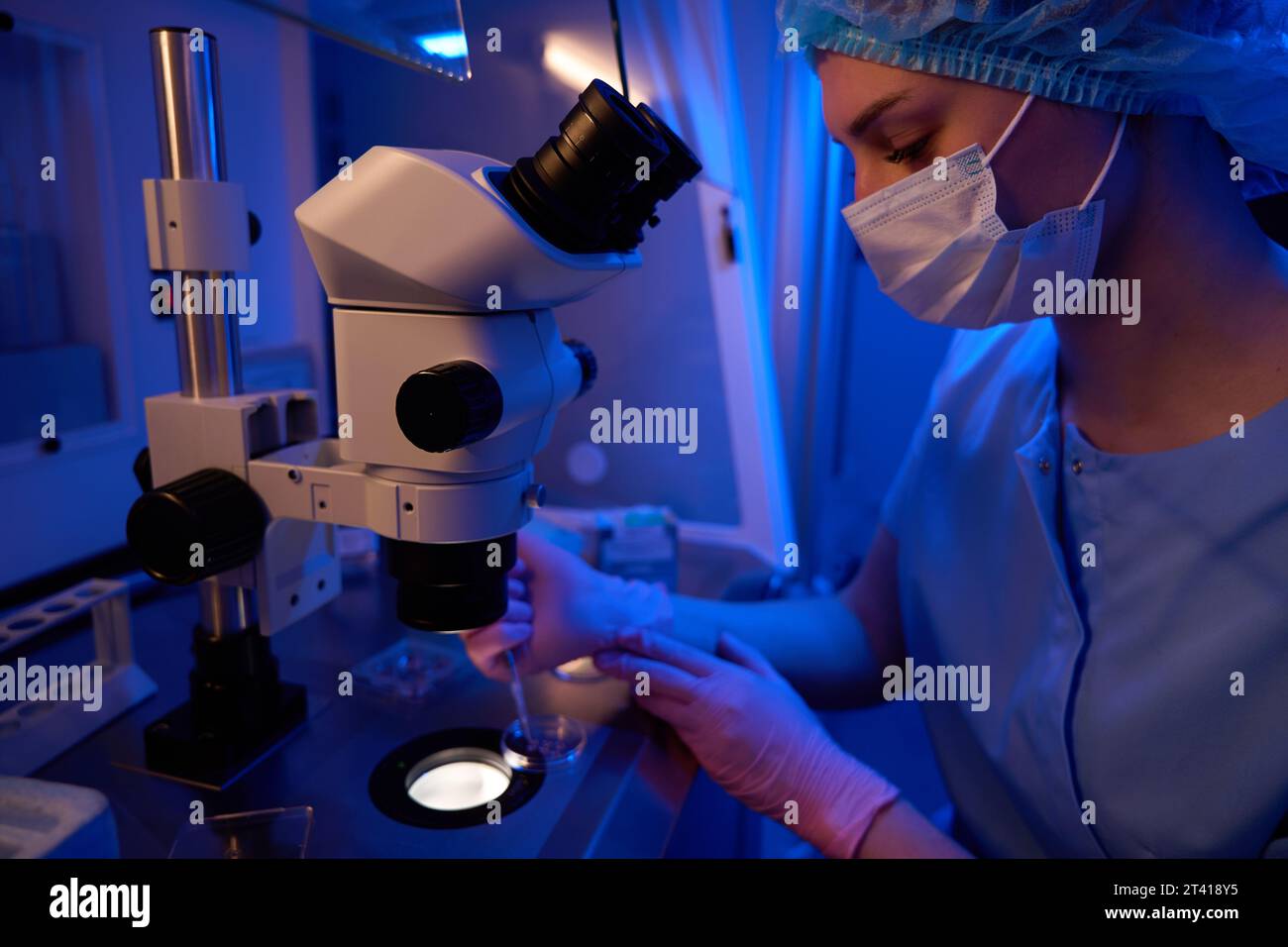 Embryologist loading biological specimens into cell-culture dish using ...