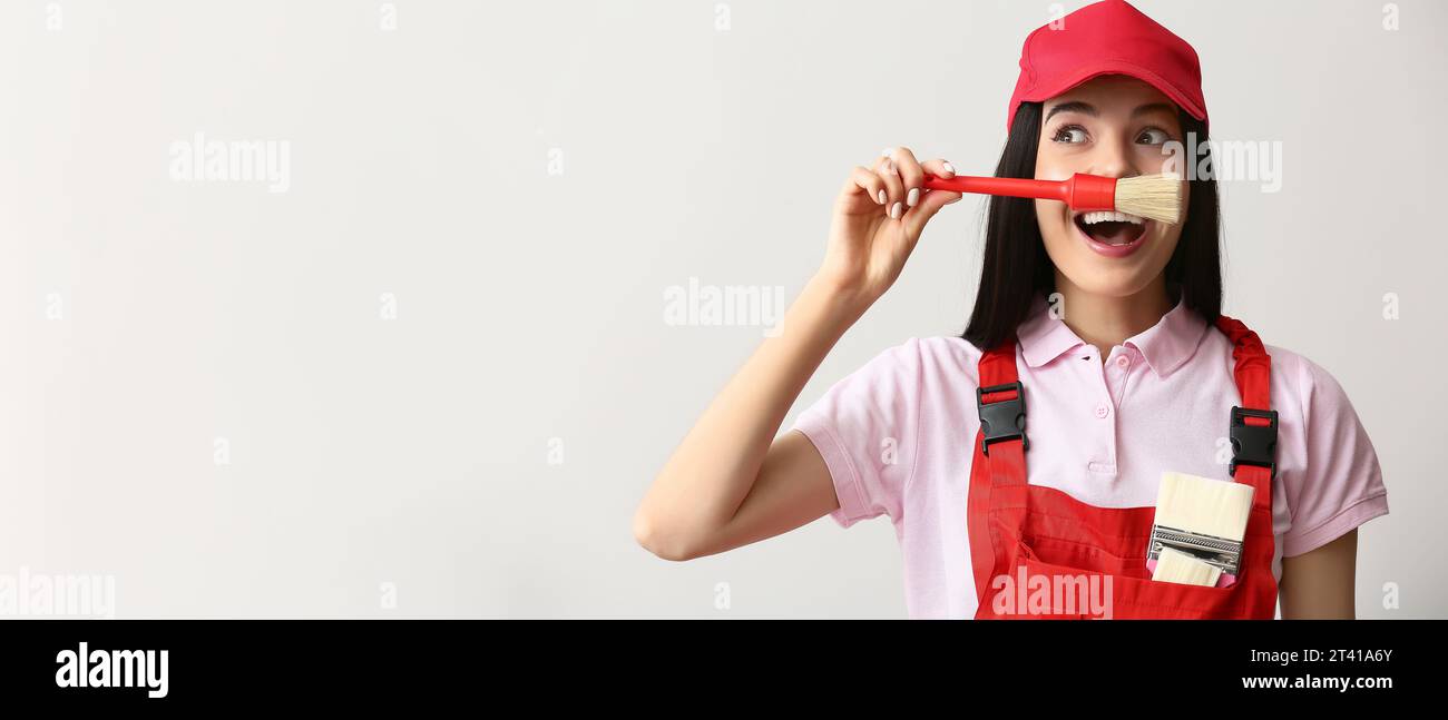 Funny female decorator with brush on light background with space for ...