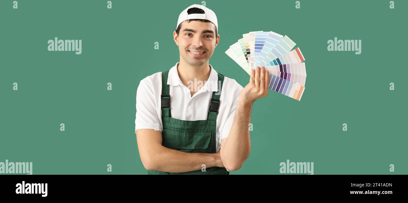 Male decorator holding color palettes on green background Stock Photo ...