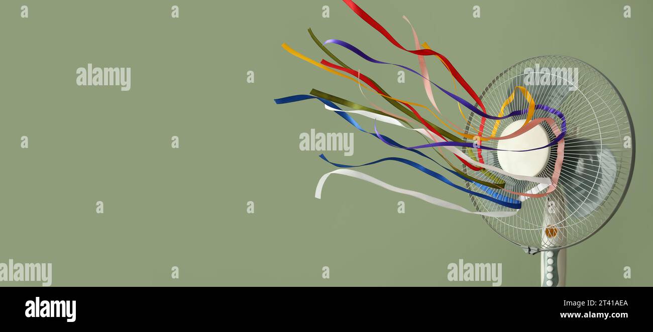 Electric fan and fluttering ribbons on green background with space for ...