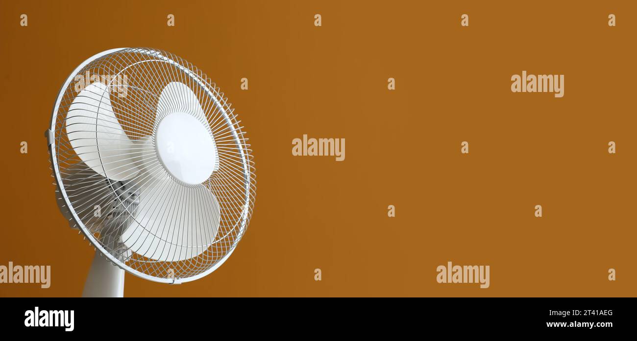 Electric fan on brown background with space for text Stock Photo - Alamy