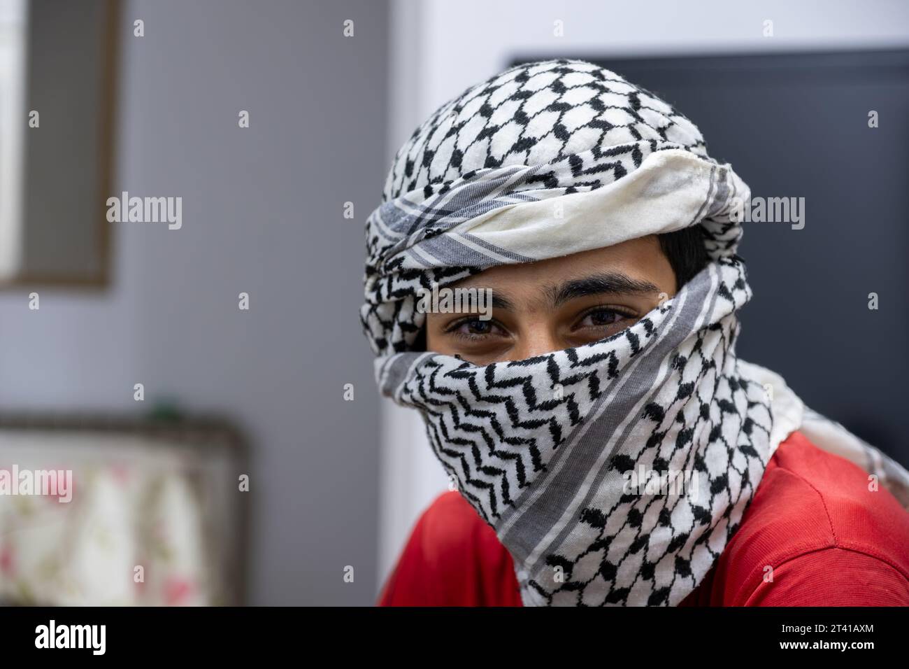 portrait of person wearing white keffiyeh on lightened background with ...