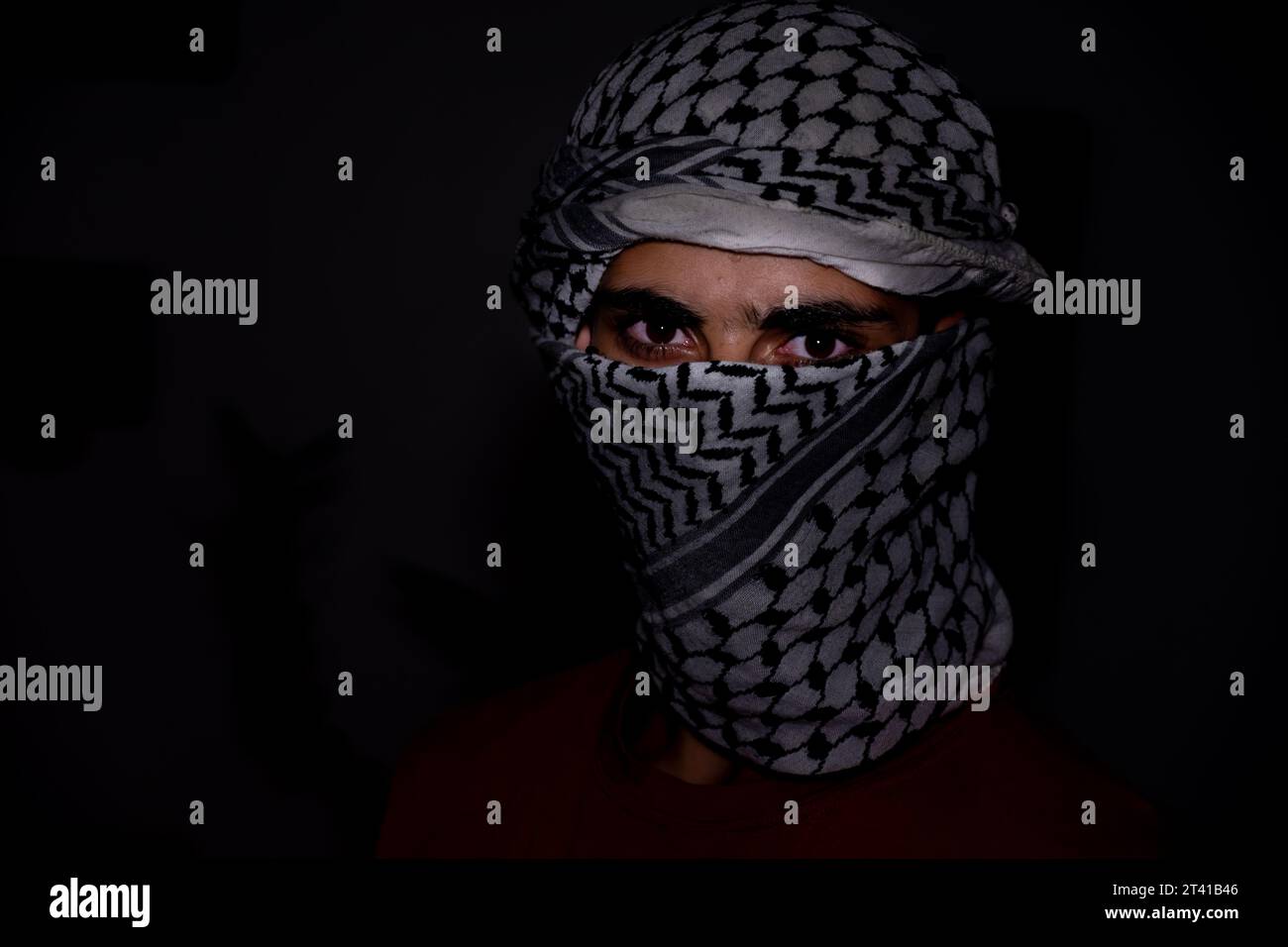portrait of pearson wearing white keffiyeh on dark background with ...