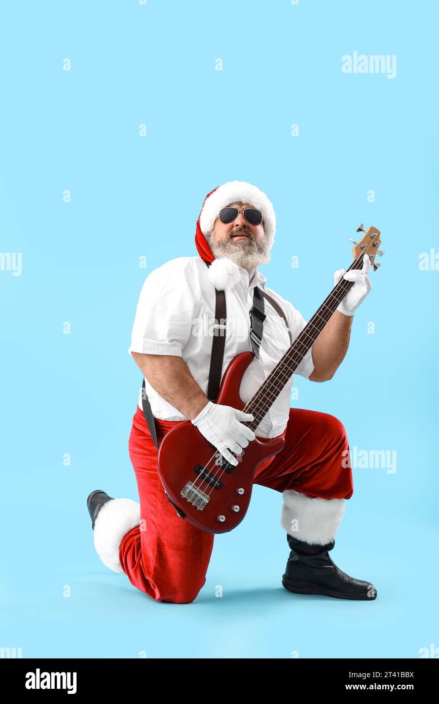 Cool Santa Claus playing guitar on blue background Stock Photo - Alamy