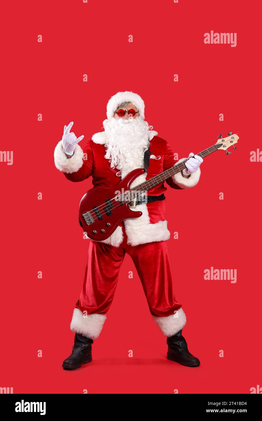 Cool Santa Claus with guitar showing "devil horns" gesture on red ...