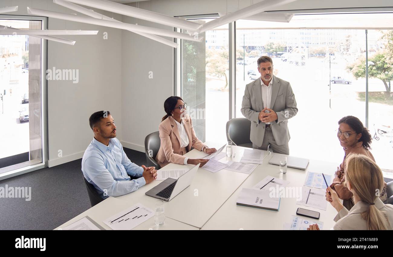 Busy senior manager leading business team meeting in office board room ...