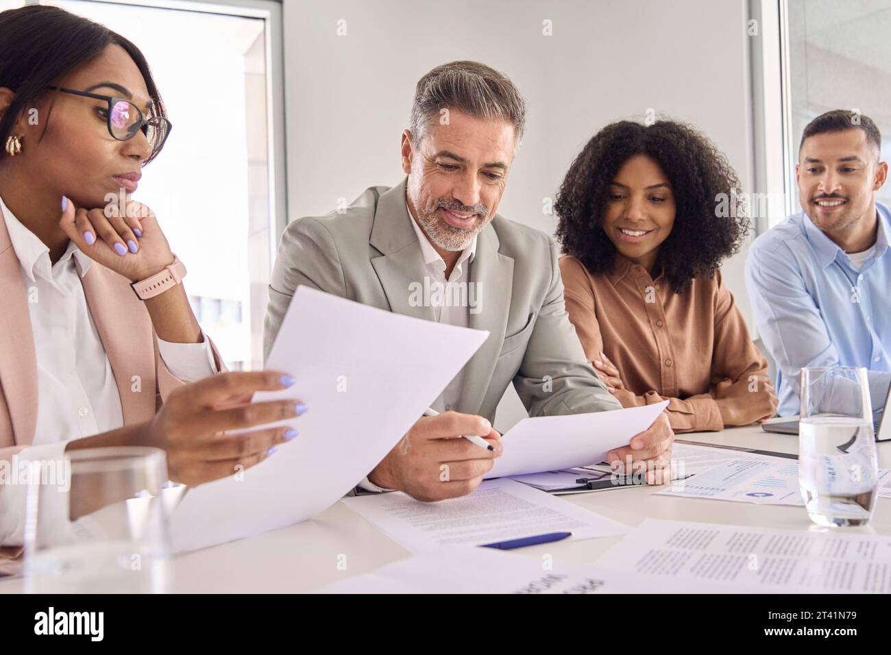 Busy smiling senior business man reading document at office team ...
