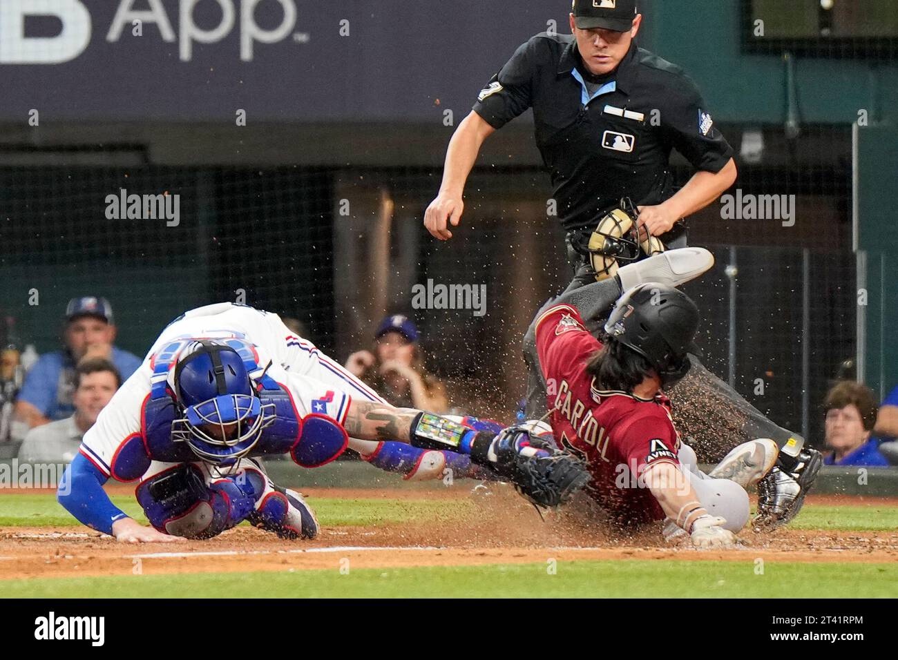 Arizona Diamondbacks' Corbin Carroll (7) scores as Texas Rangers catcher Jonah Heim reaches to ...
