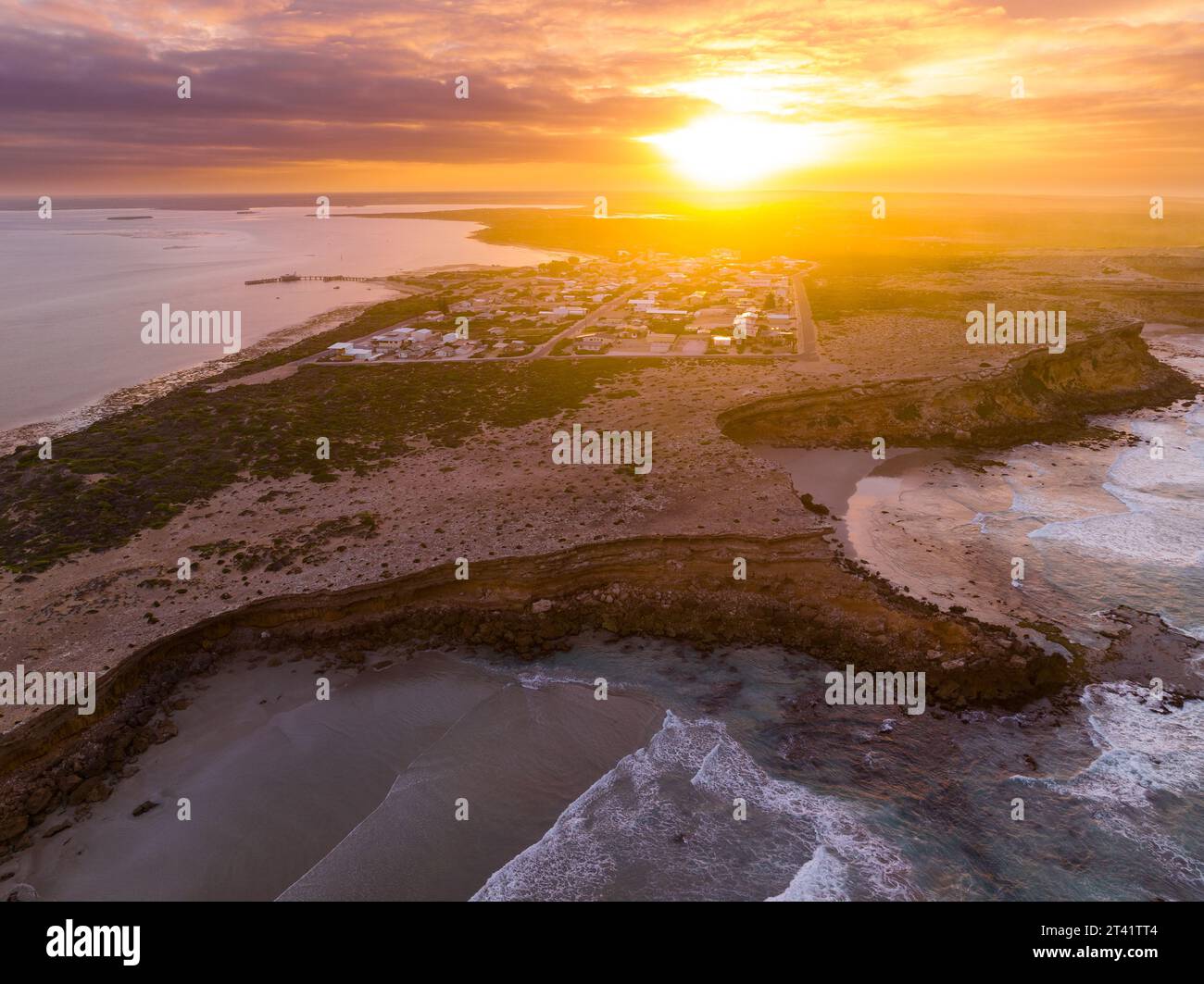 Aerial view of a coastal town perched on rugged cliff tops during ...