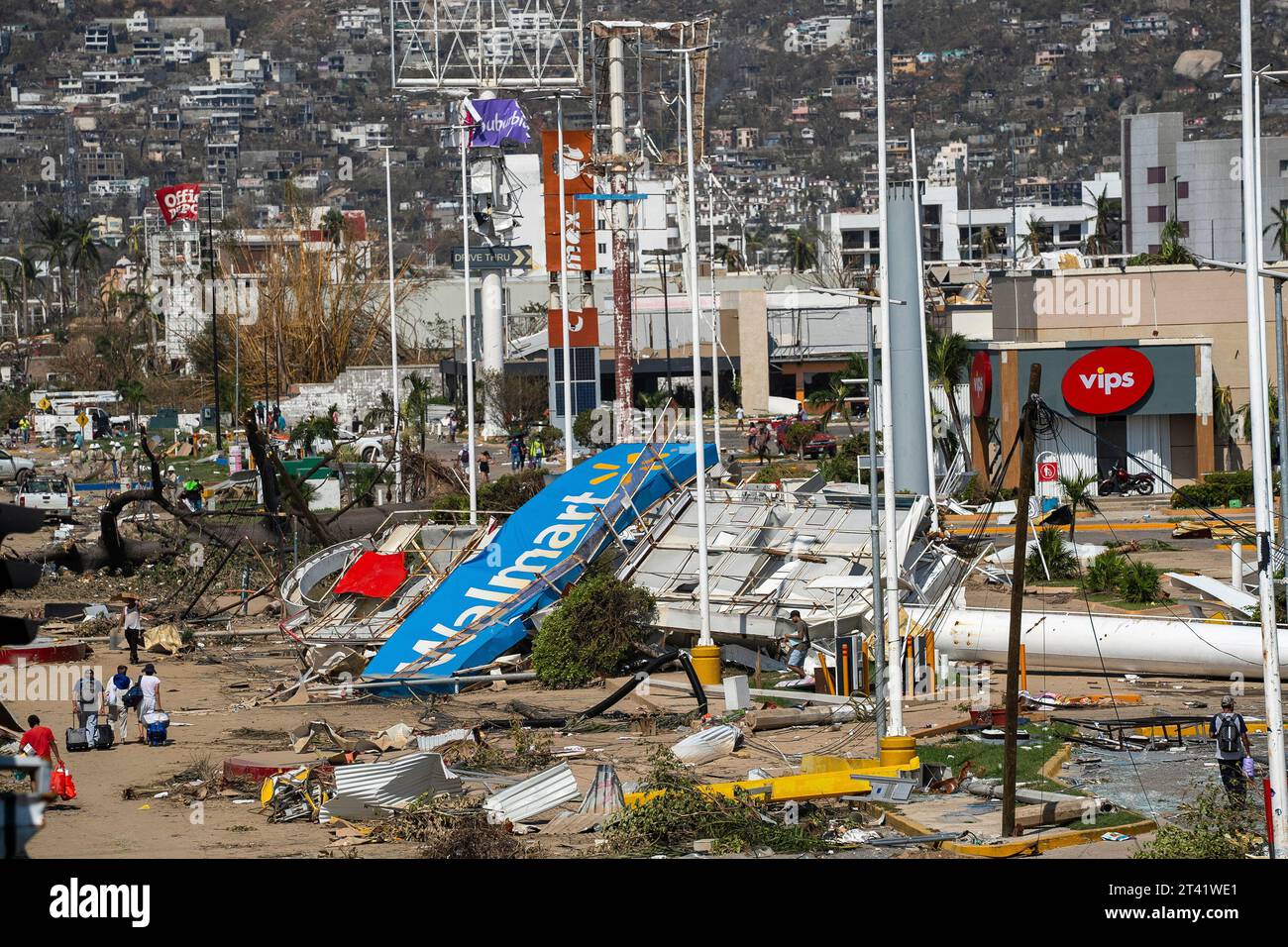 Residents walk past debris in the aftermath of Hurricane Otis in ...