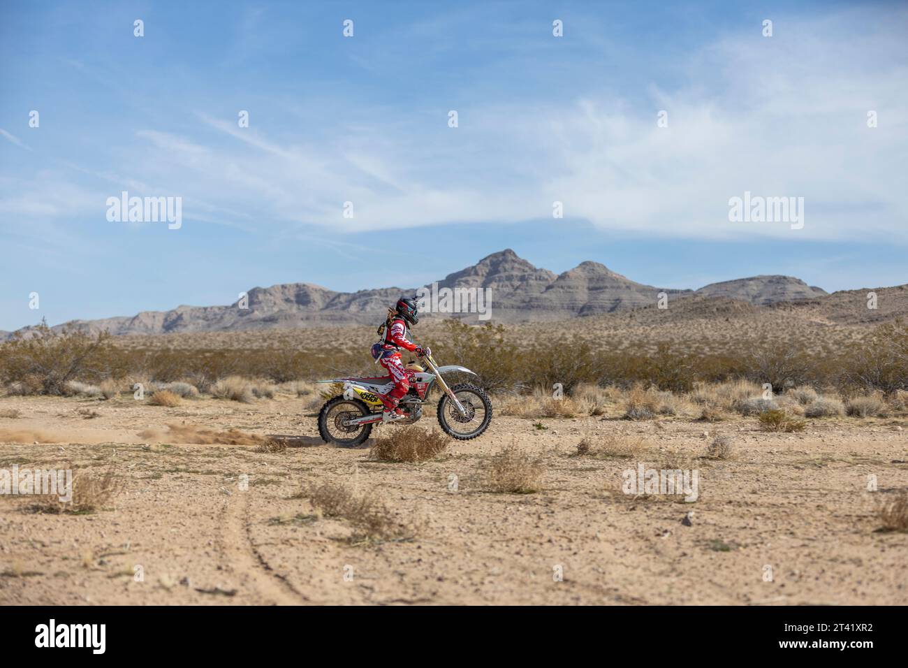 A man is riding a motorcycle while navigating the dusty desert ...