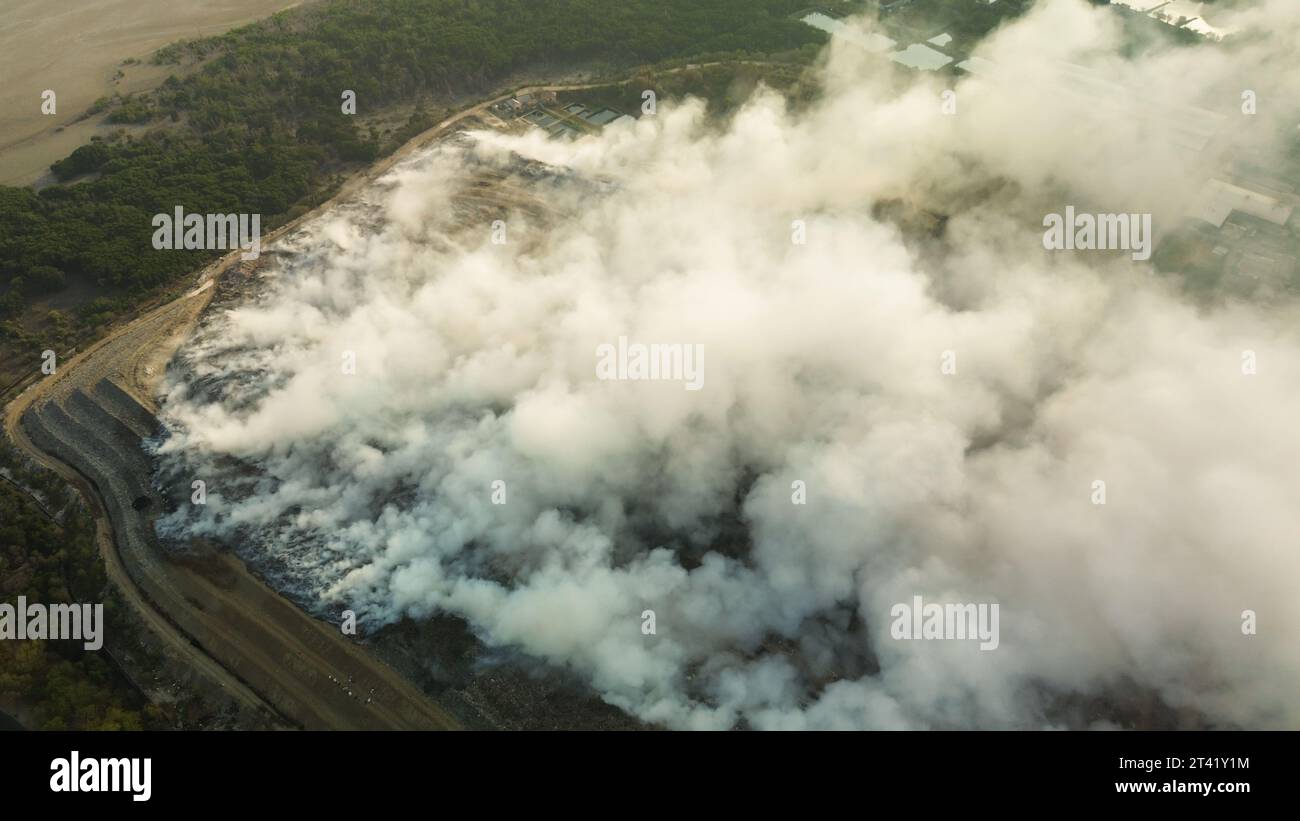 Top view of a fire at a landfill with plastic waste. An environmental ...