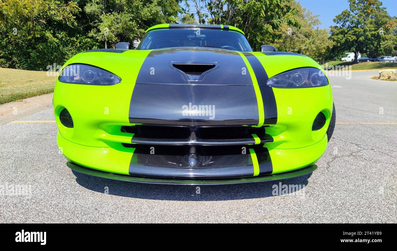 A vibrant lime green sports car is parked on a city street, with a ...