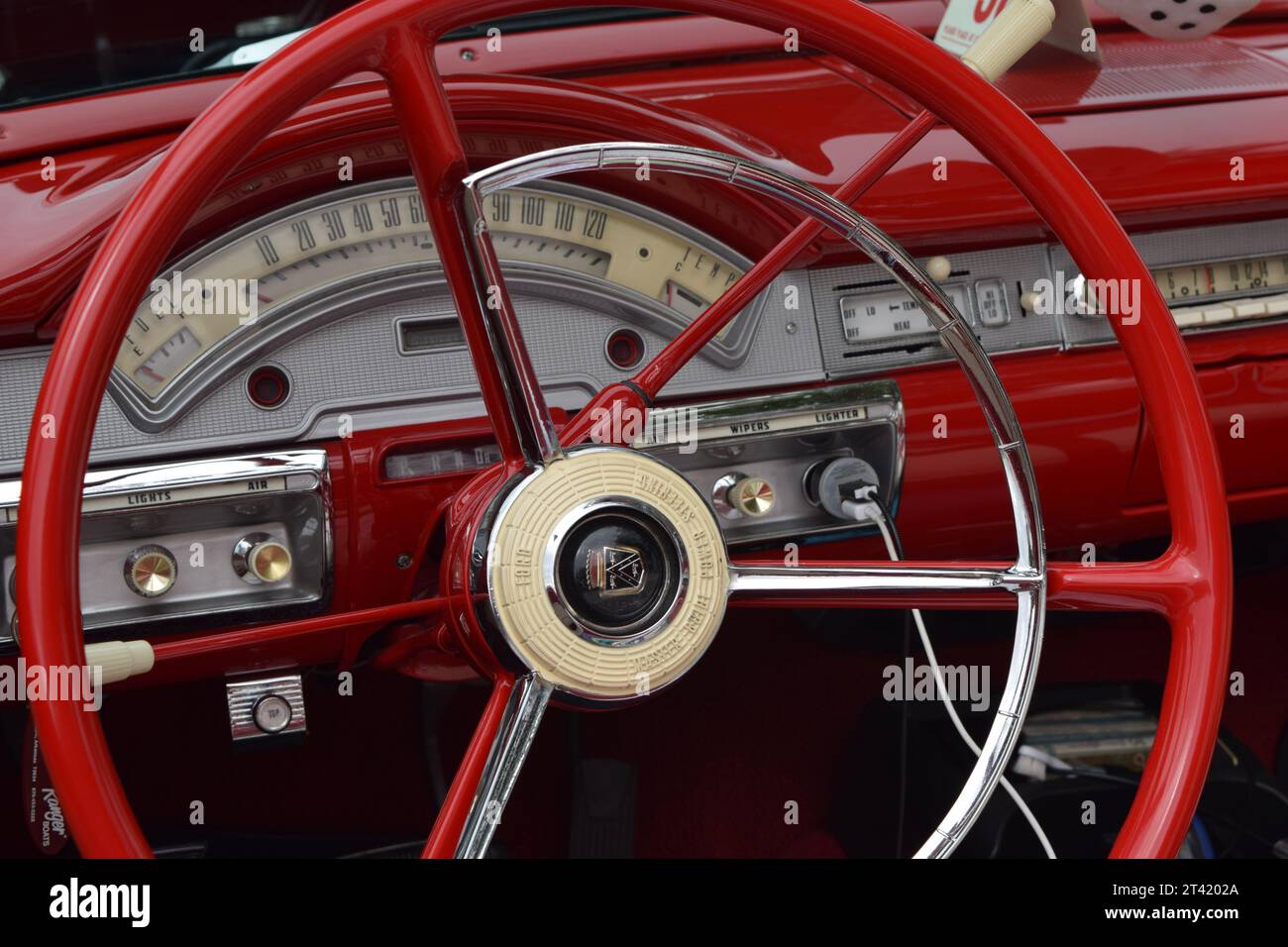 This image captures the interior of a classic red car with vintage ...