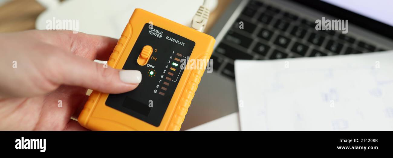 Woman holds LAN speed tester near Wi-Fi router and laptop Stock Photo ...