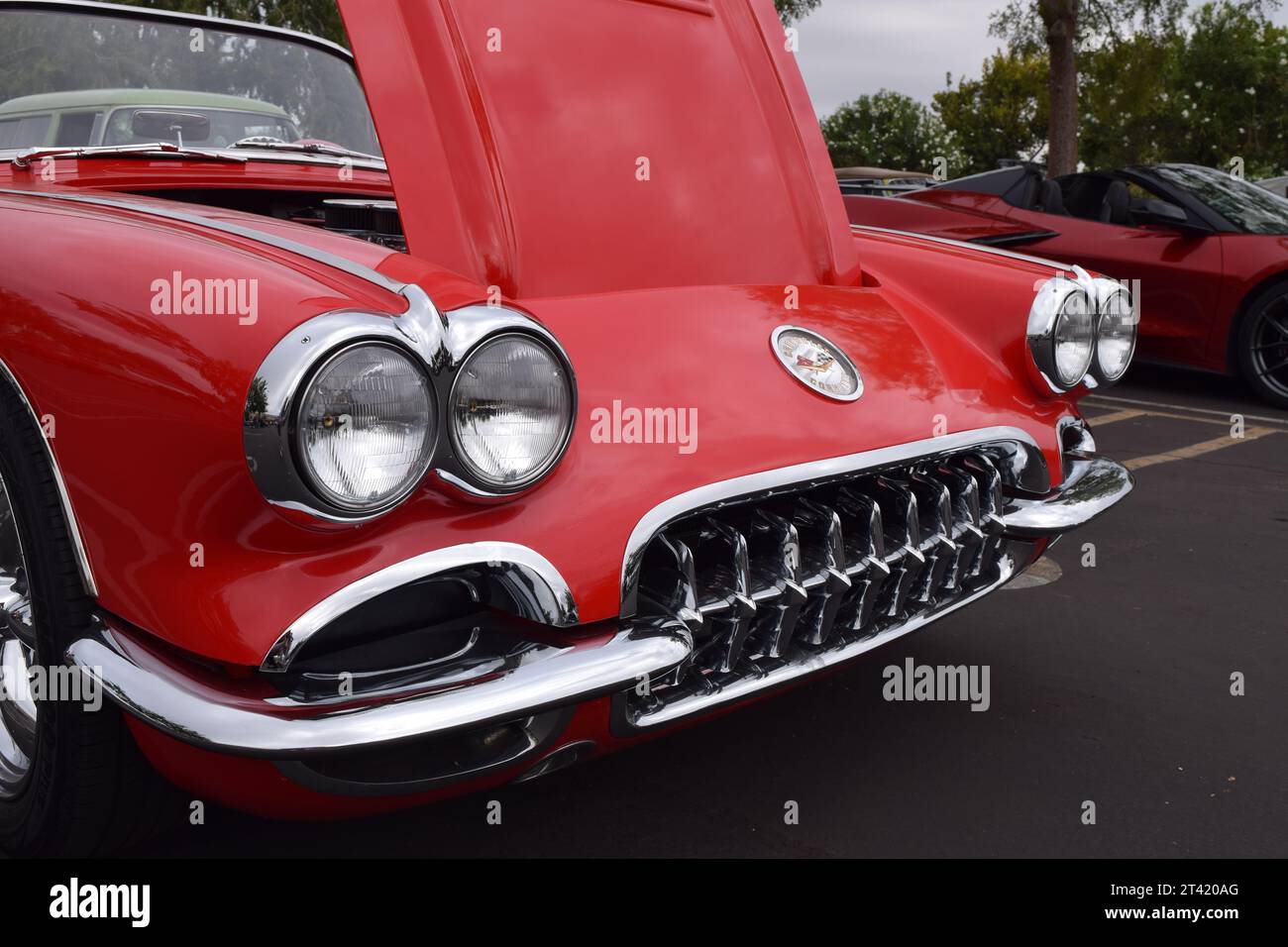 A classic red convertible Corvette with its hood opened, showcasing the ...