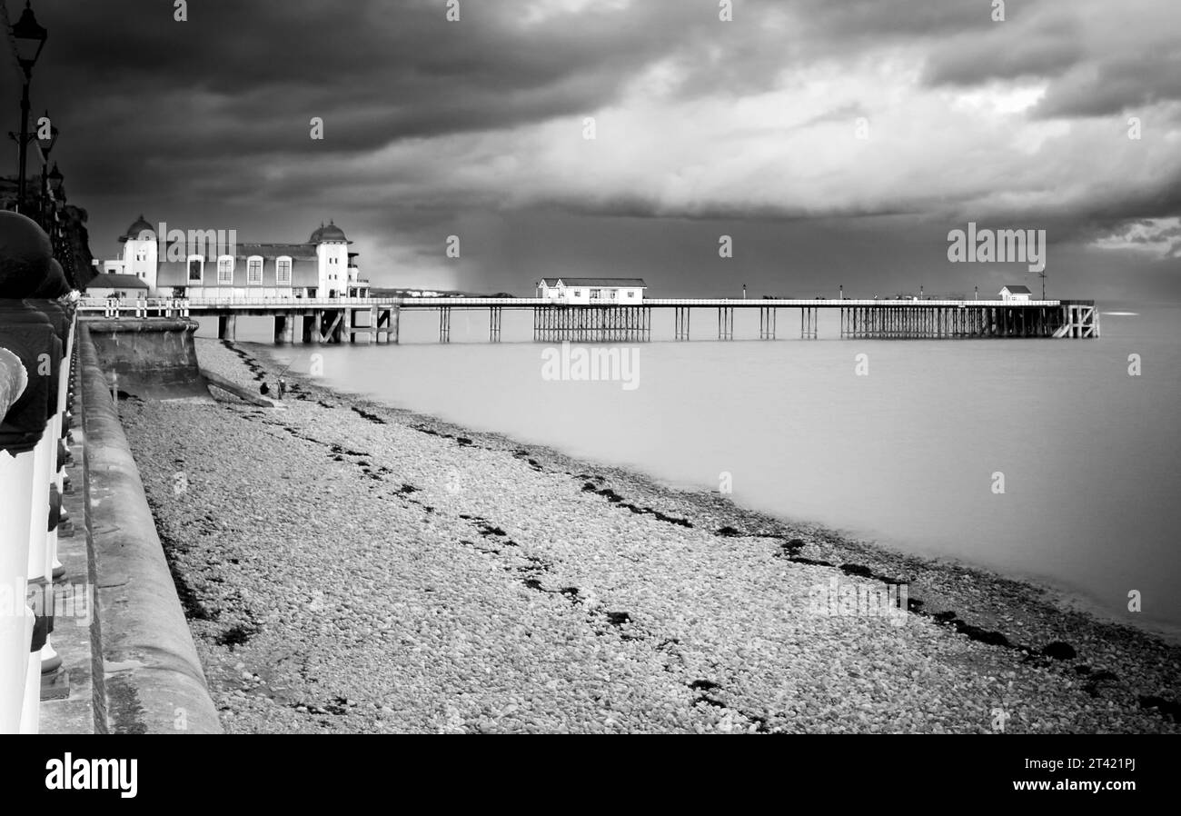 An artistic black and white image of a pier jutting out over the ocean ...
