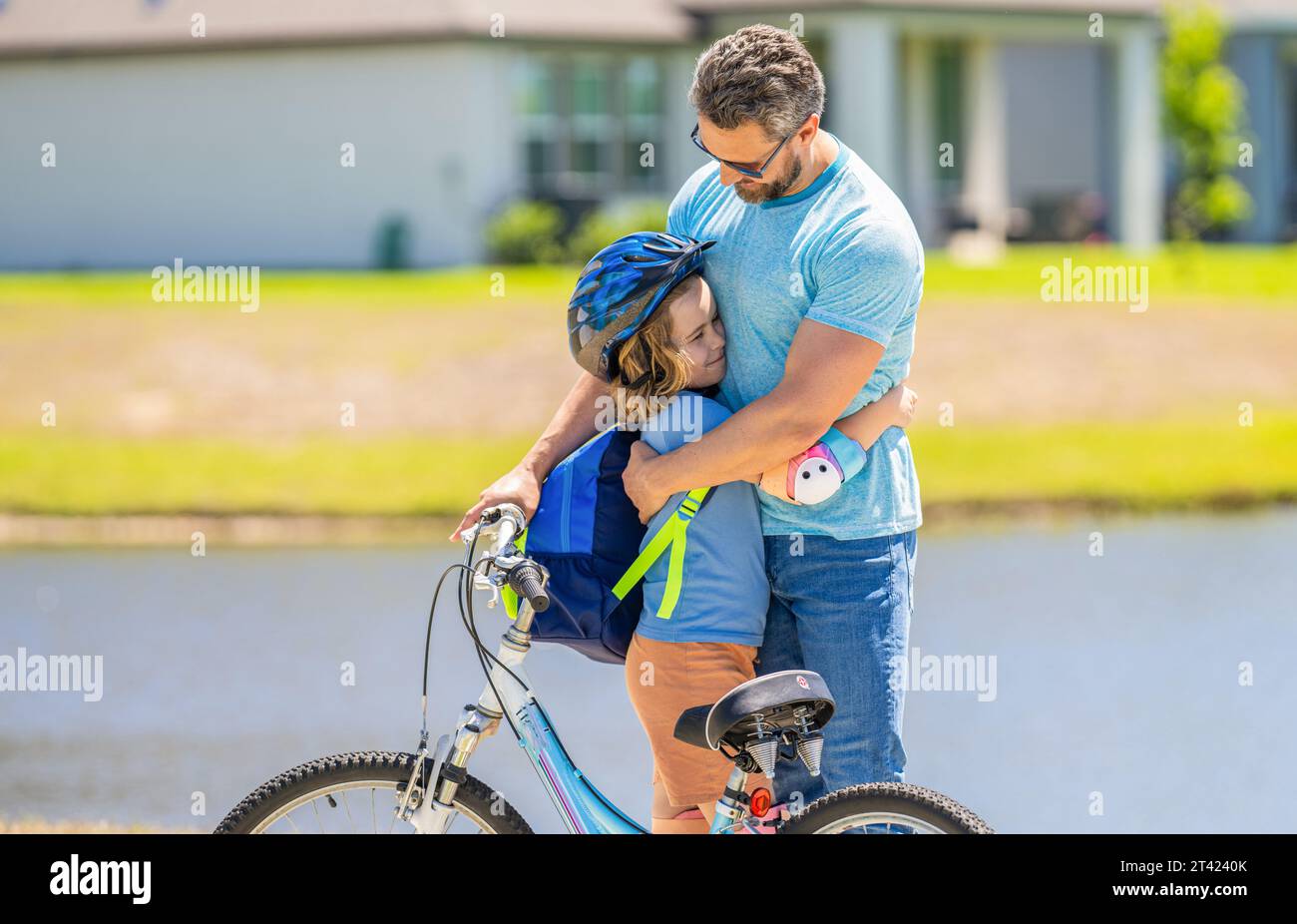 father hugging son on bicycle at fathers day. father setting a example ...