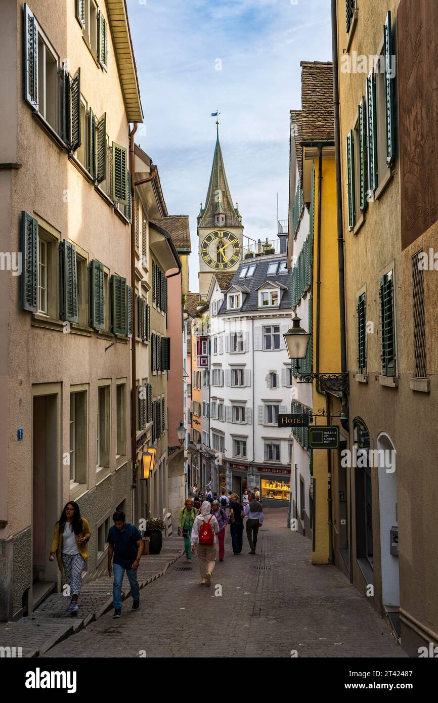 Narrow streets of the old town of Zurich, steeple of St. Peter's Church ...
