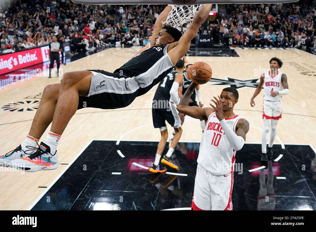 San Antonio Spurs forward Keldon Johnson (3) hangs from the rim after a ...