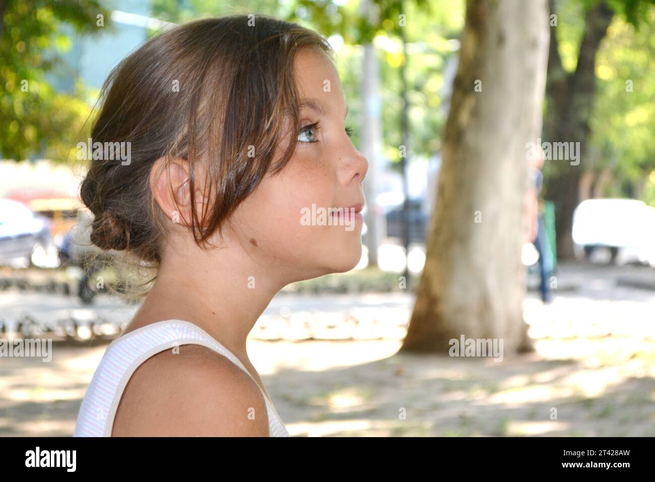 Cute kid girl 10 year old posing on nature background. Looking at ...