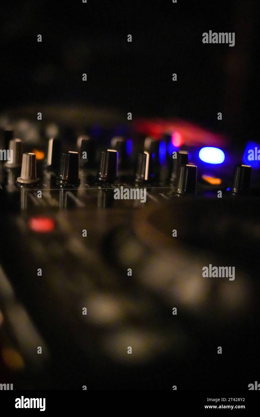 An electronic DJ turntable and controller illuminated in the darkness ...