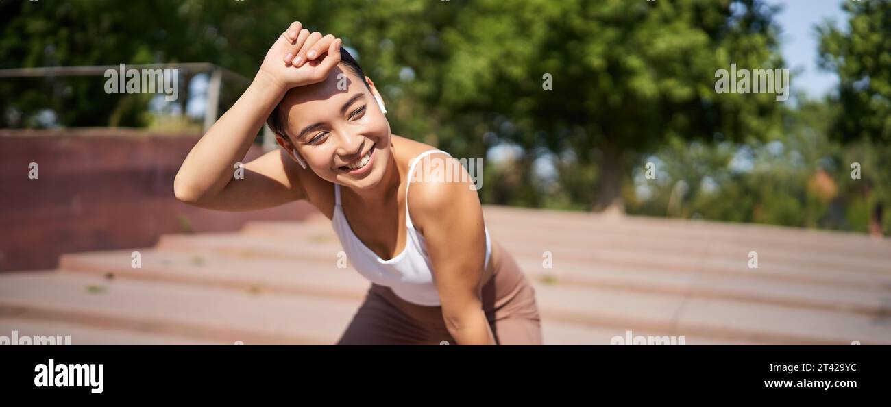 Portrait of asian woman taking break, breathing heavily and panting ...