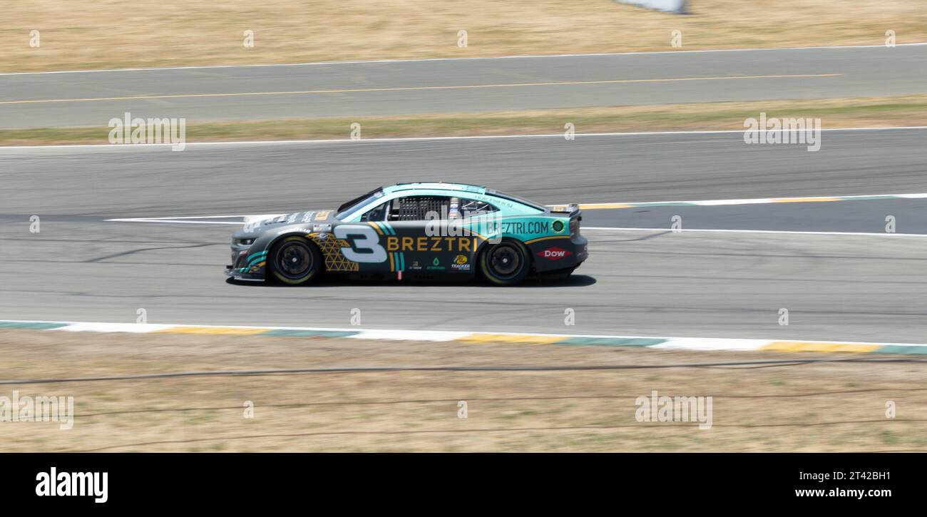 A close-up of a bright red racing car turning sharply around a race ...