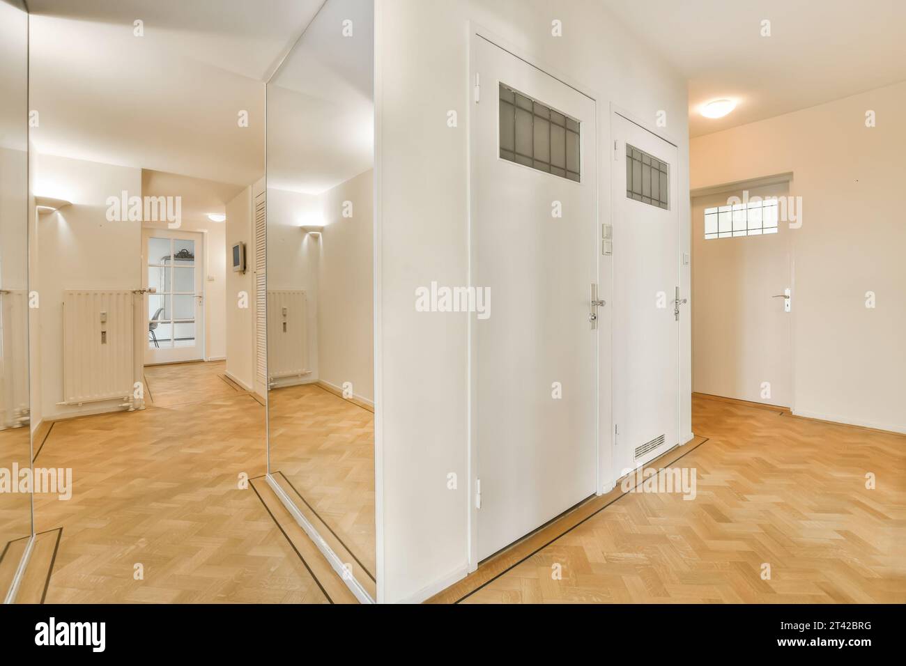 an empty room with some mirrors on the wall and two doors in the ...