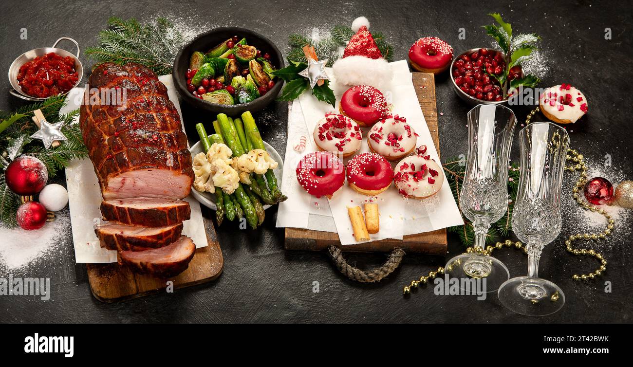 Baked ham with vegetablesand donuts on dark background. Christmas food ...