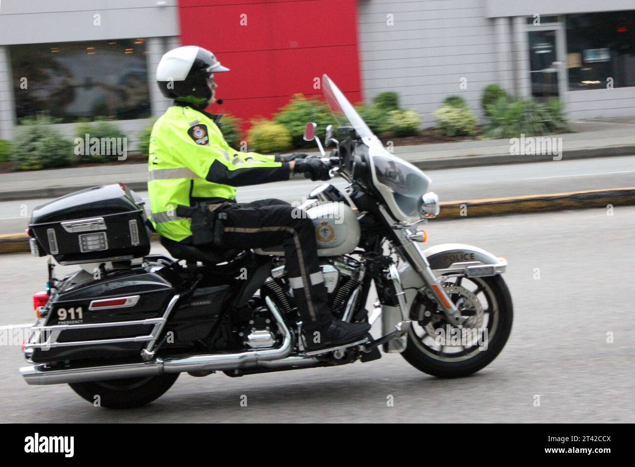 A police officer wearing a blue uniform parked on his motorcycle in a ...
